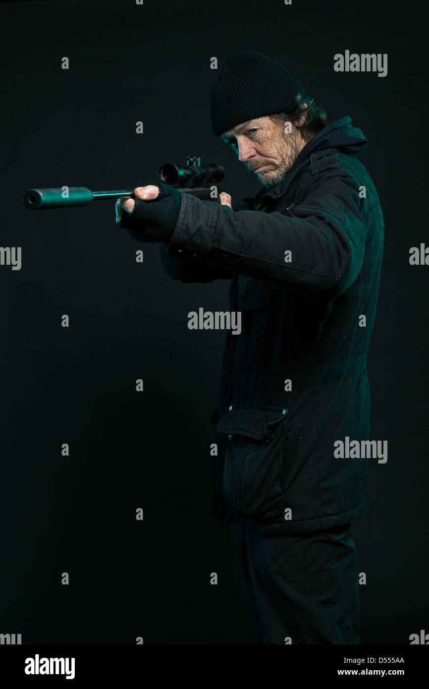 Sniper with beard in black holding gun. Studio shot Stock Photo - Alamy