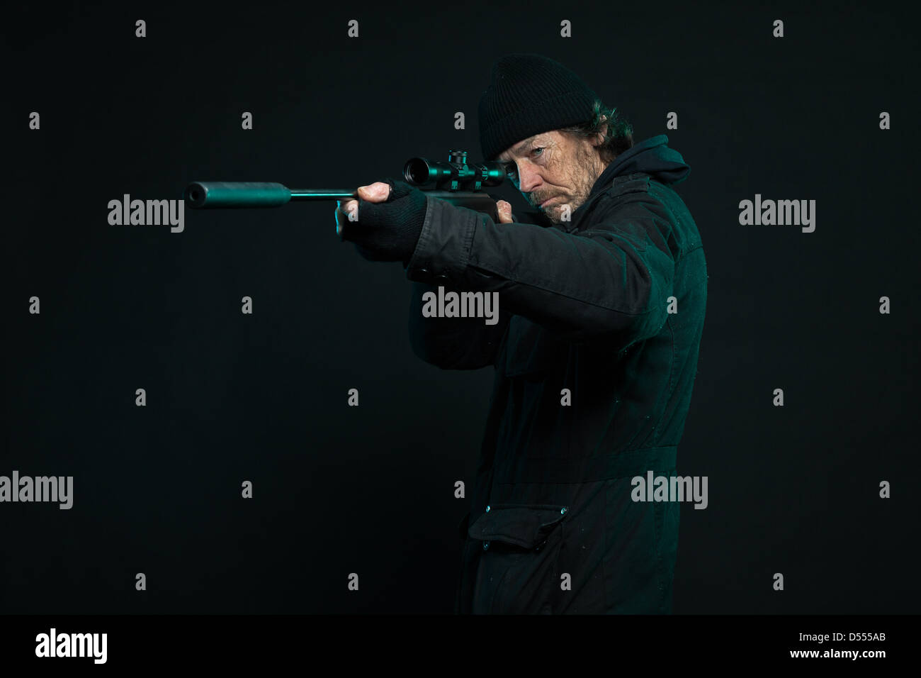 Sniper with beard in black holding gun. Studio shot Stock Photo - Alamy