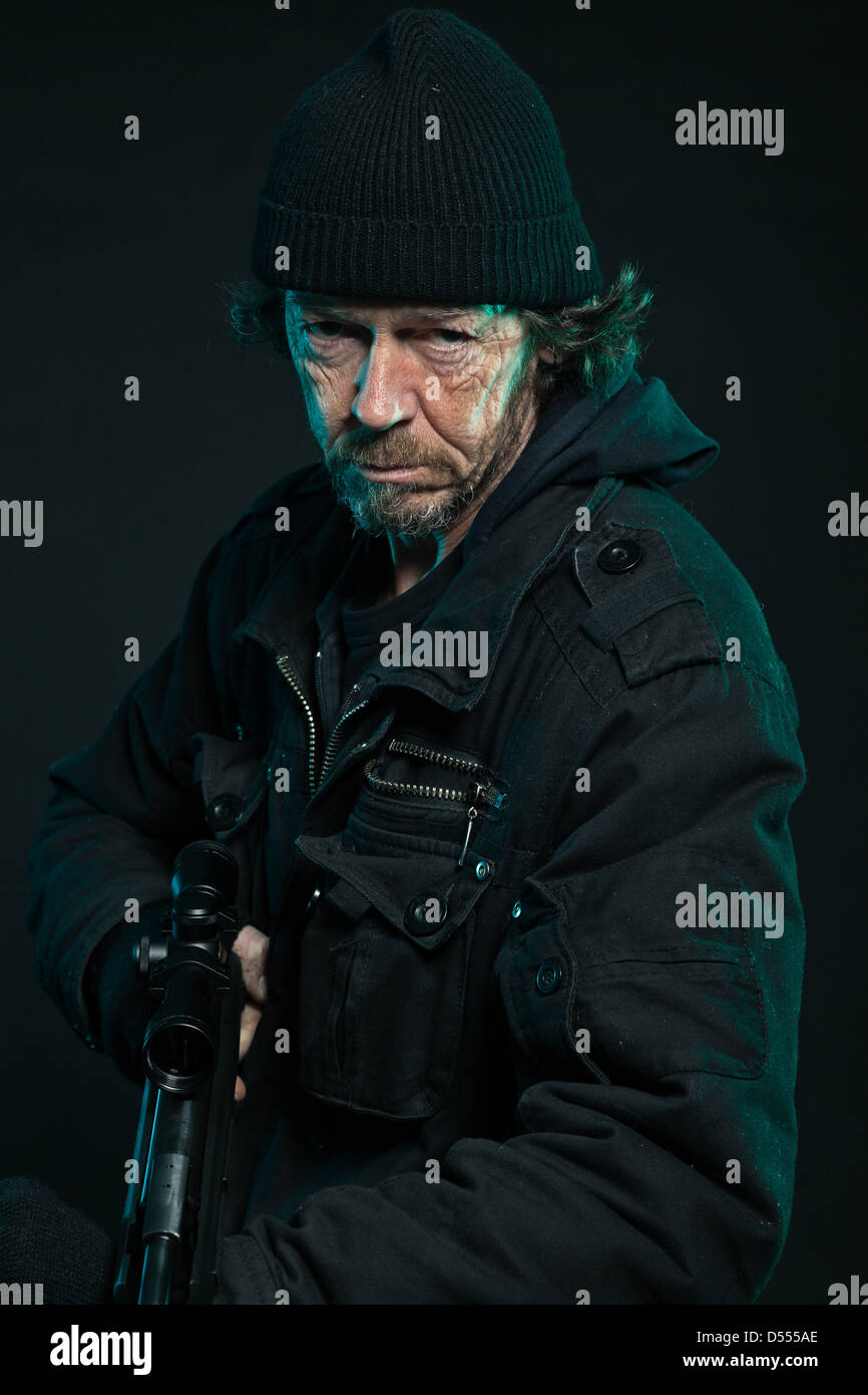 Sniper with beard in black holding gun. Studio shot Stock Photo - Alamy