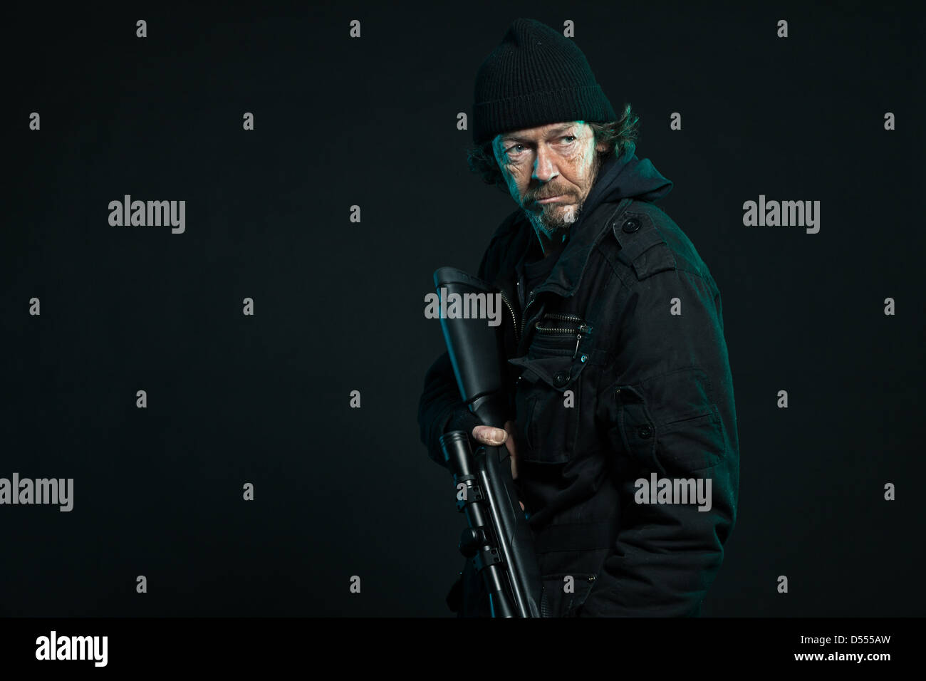 Sniper with beard in black holding gun. Studio shot Stock Photo - Alamy