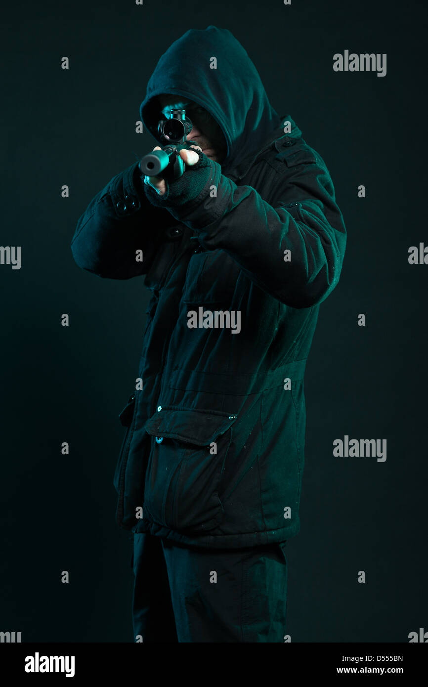 Sniper with beard in black holding gun. Studio shot Stock Photo - Alamy