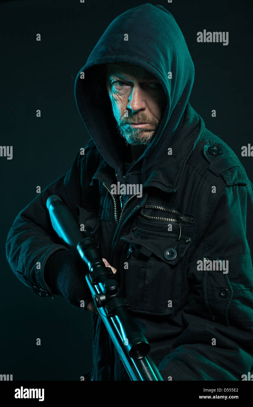 Sniper with beard in black holding gun. Studio shot Stock Photo - Alamy