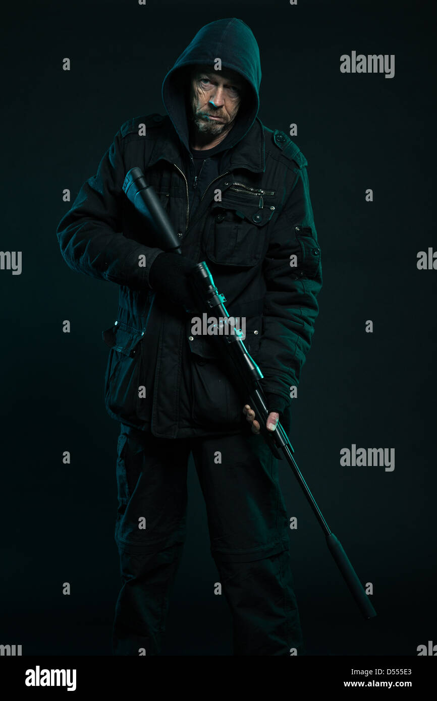 Sniper with beard in black holding gun. Studio shot Stock Photo - Alamy