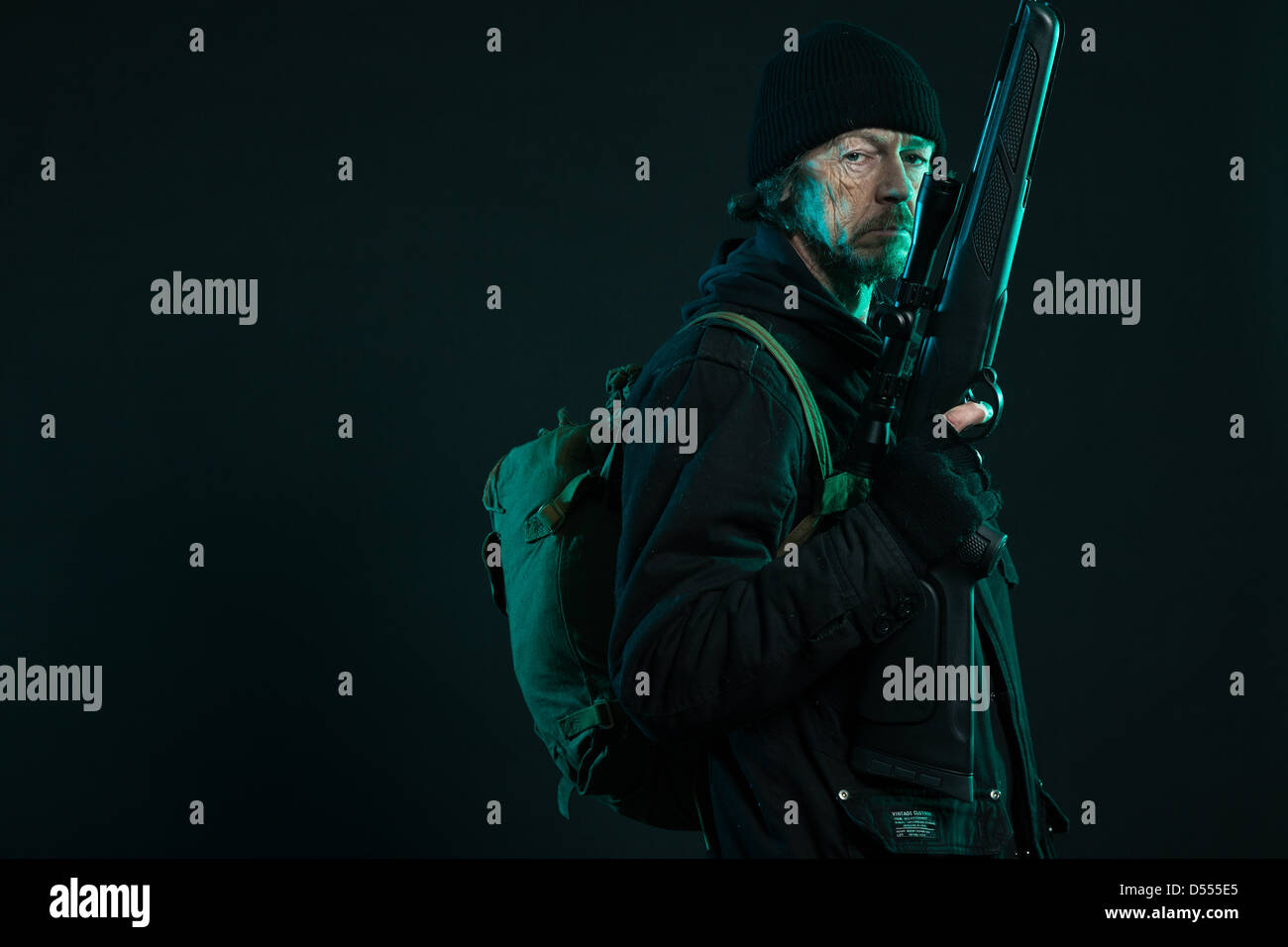 Sniper with beard in black holding gun. Studio shot Stock Photo - Alamy