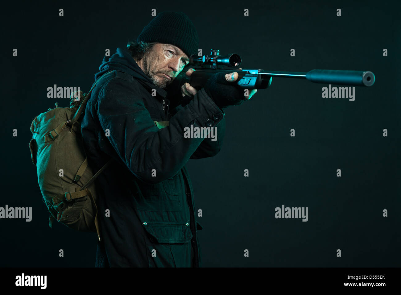 Sniper with beard in black holding gun. Studio shot Stock Photo - Alamy