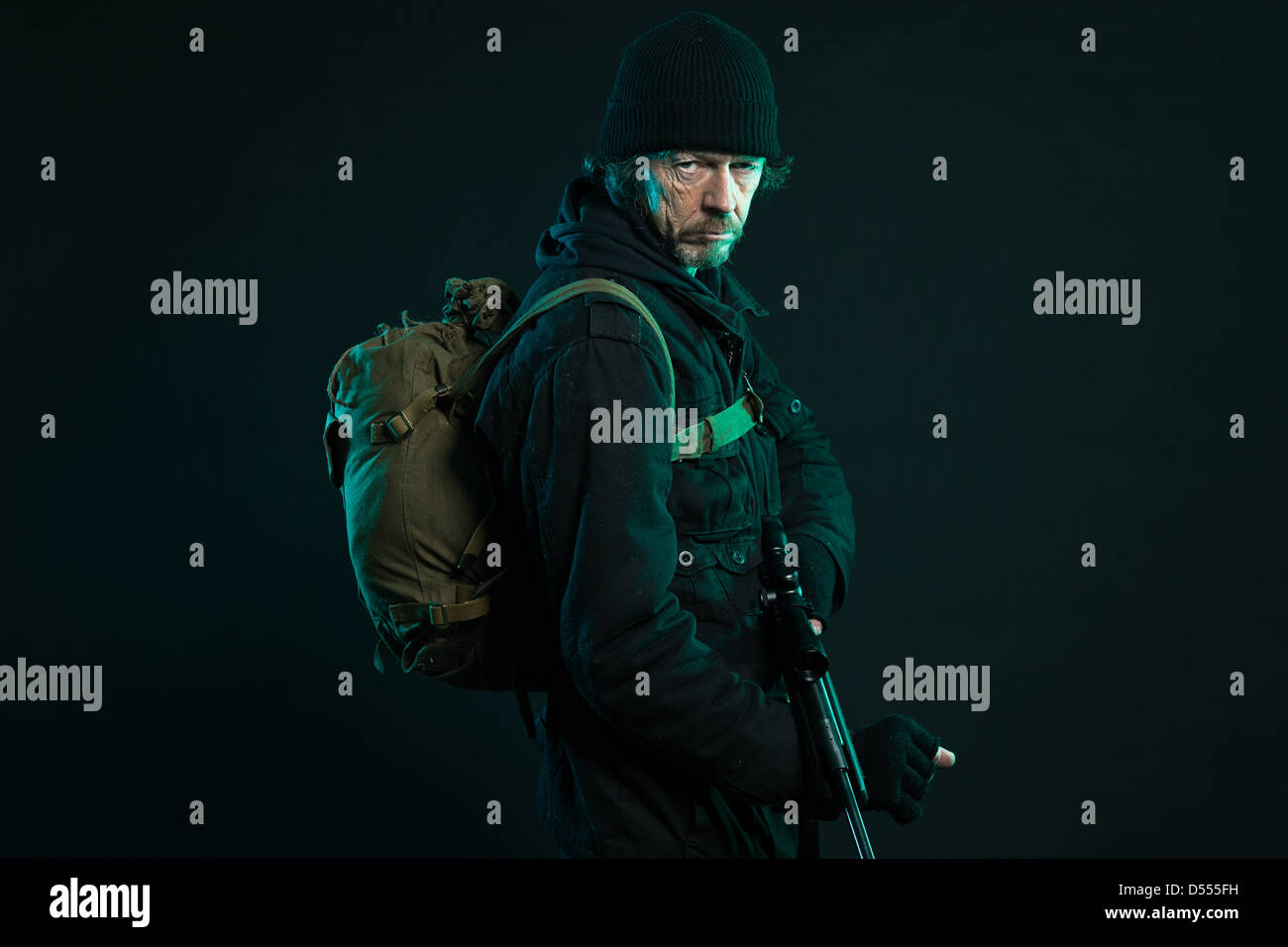 Sniper with beard in black holding gun. Studio shot Stock Photo - Alamy