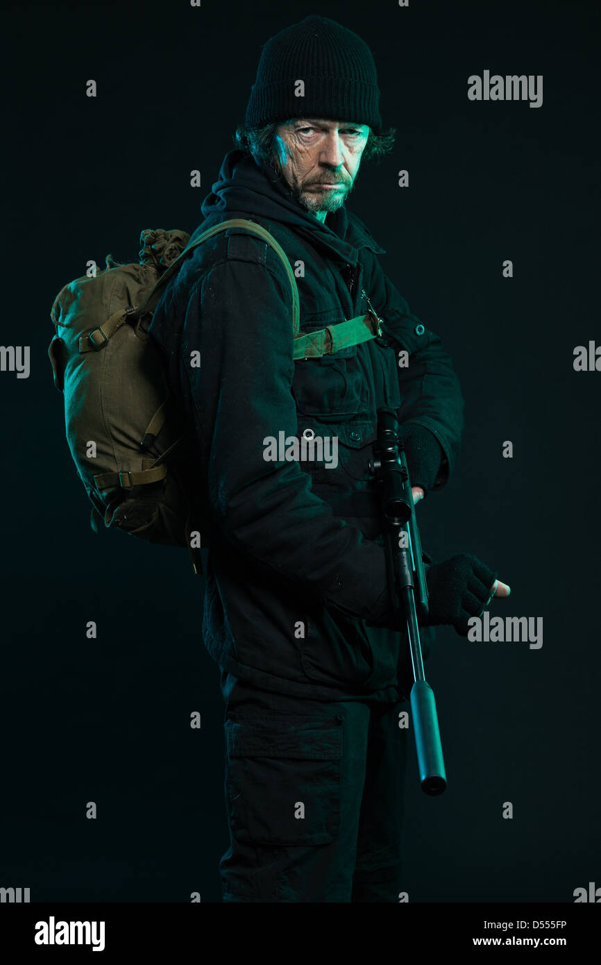 Sniper with beard in black holding gun. Studio shot Stock Photo - Alamy