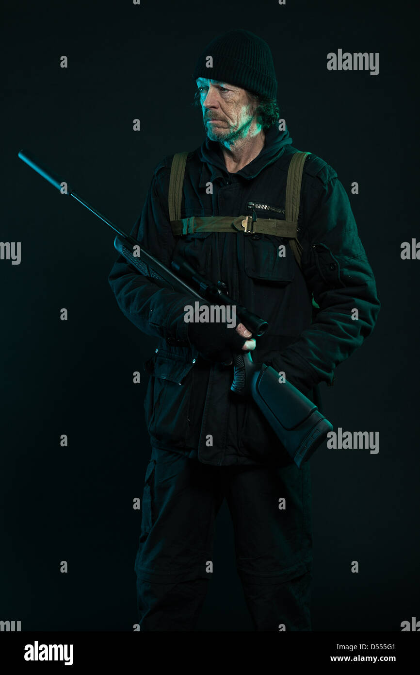 Sniper with beard in black holding gun. Studio shot Stock Photo - Alamy
