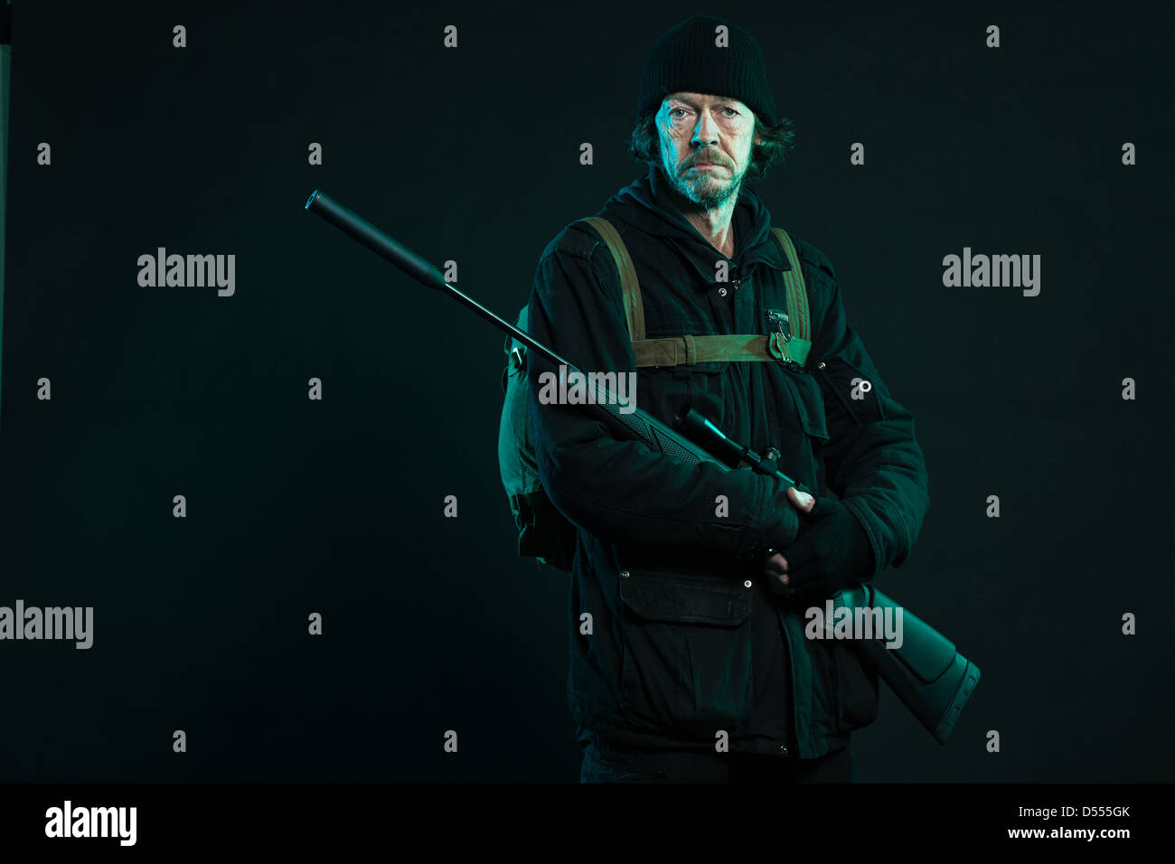 Sniper with beard in black holding gun. Studio shot Stock Photo - Alamy