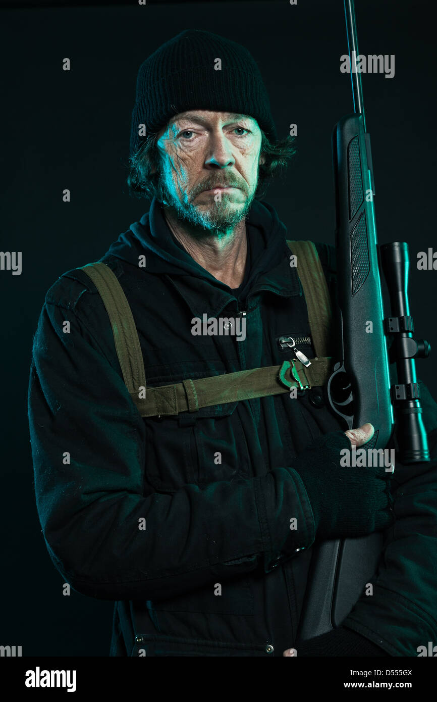 Sniper with beard in black holding gun. Studio shot Stock Photo - Alamy