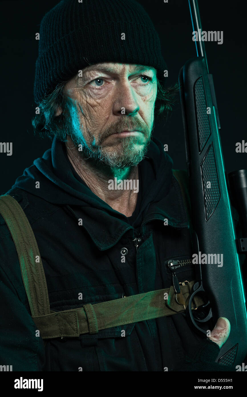 Sniper with beard in black holding gun. Studio shot Stock Photo - Alamy