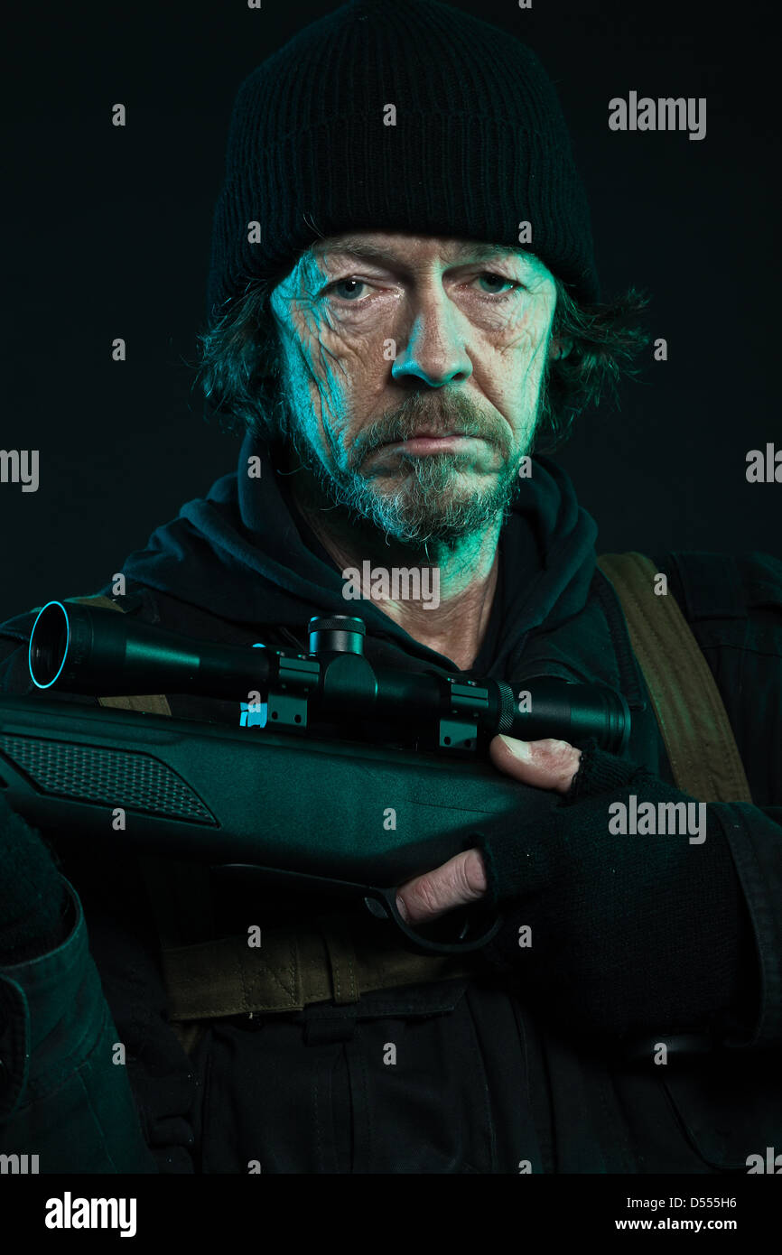 Sniper with beard in black holding gun. Studio shot Stock Photo - Alamy