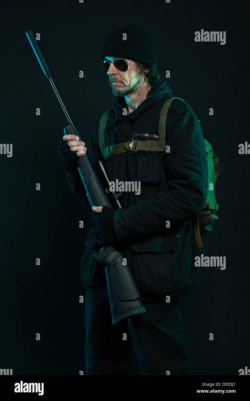 Sniper with beard in black holding gun. Studio shot Stock Photo - Alamy