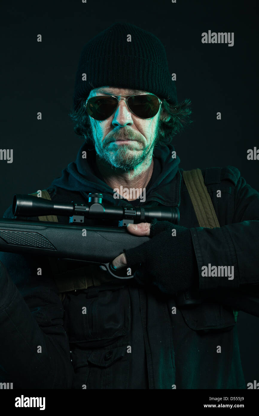 Sniper with beard in black holding gun. Studio shot Stock Photo - Alamy