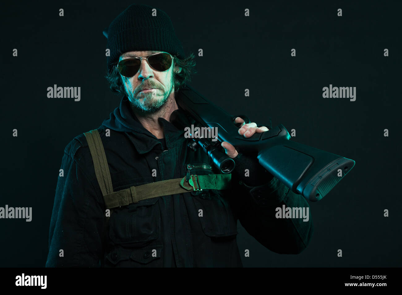 Sniper with beard in black holding gun. Studio shot Stock Photo - Alamy