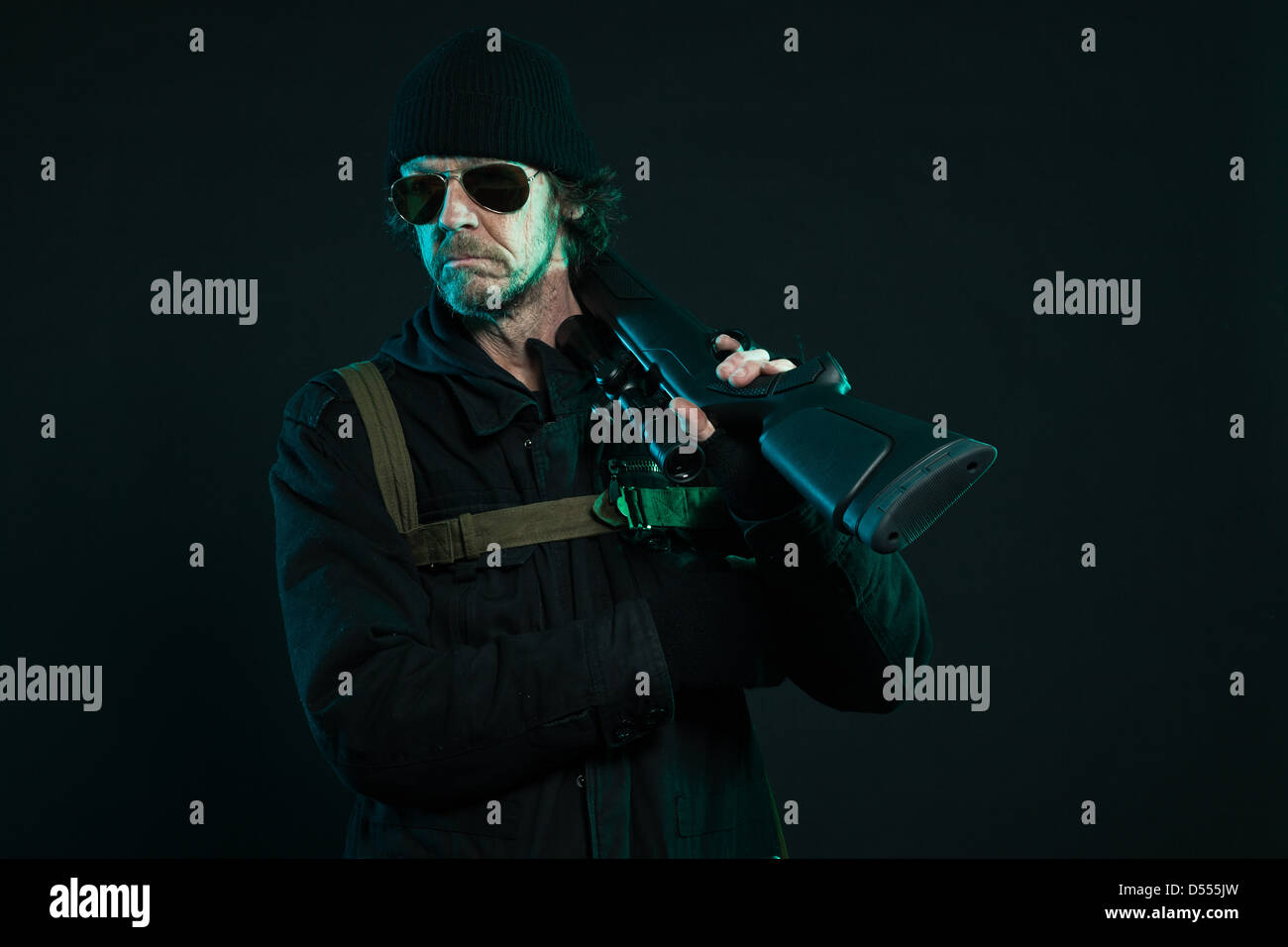 Sniper with beard in black holding gun. Studio shot Stock Photo - Alamy