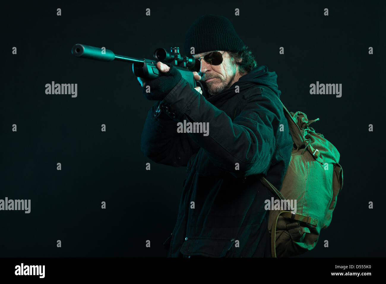 Sniper with beard in black holding gun. Studio shot Stock Photo - Alamy