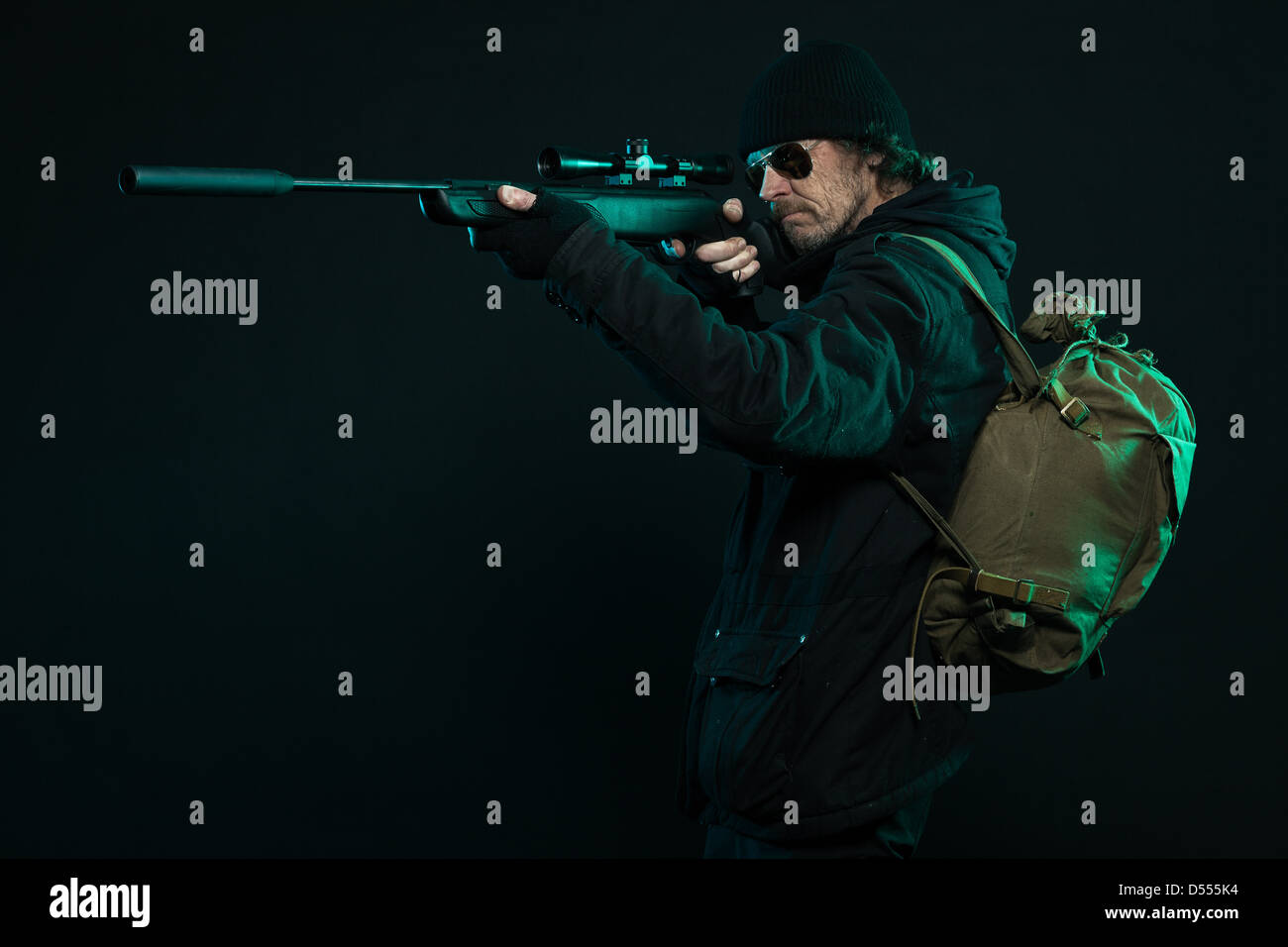 Sniper with beard in black holding gun. Studio shot Stock Photo - Alamy