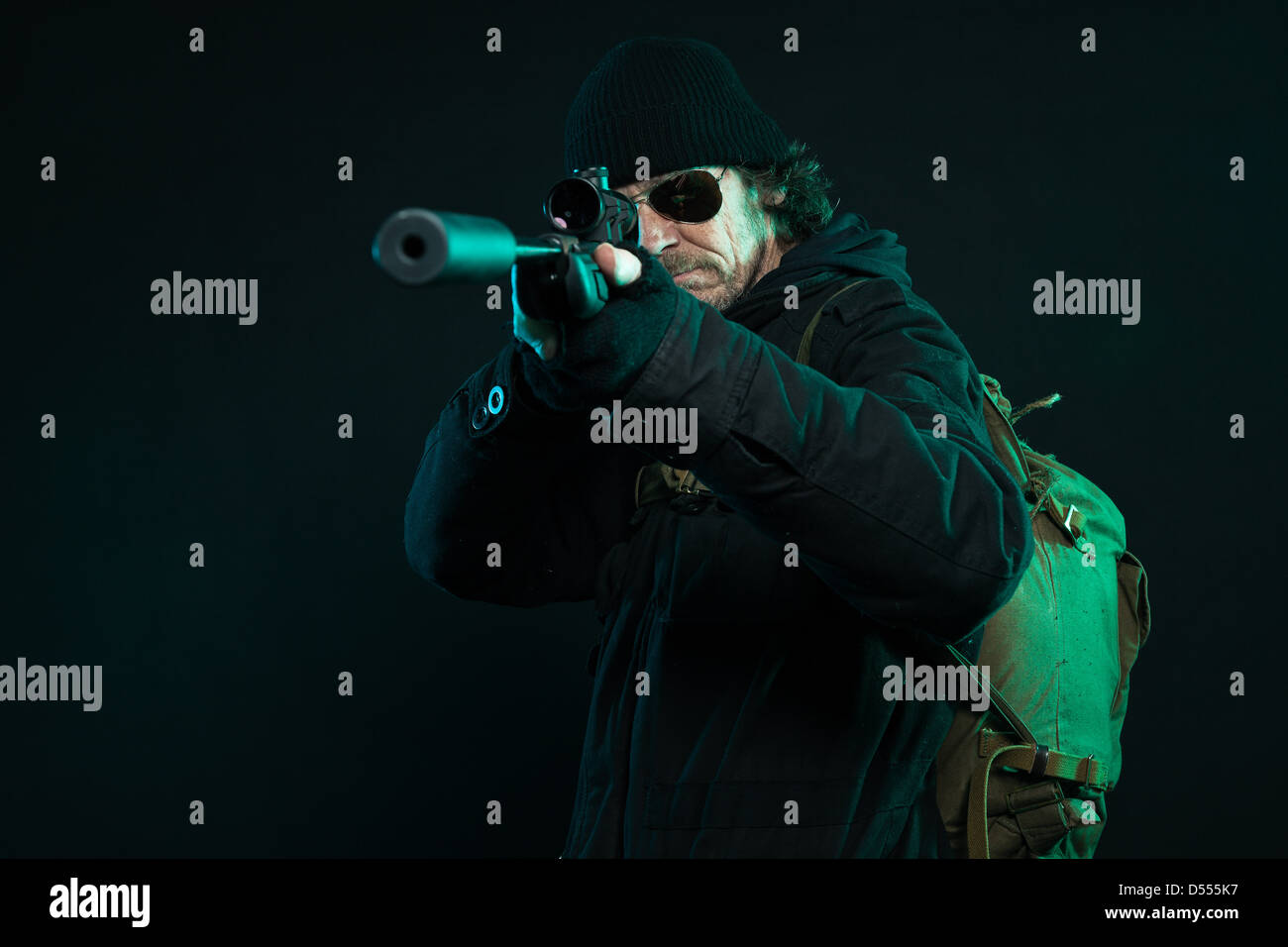 Sniper with beard in black holding gun. Studio shot Stock Photo - Alamy