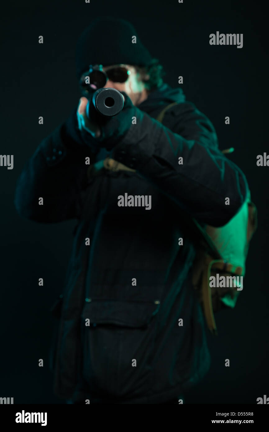 Sniper with beard in black holding gun. Studio shot Stock Photo - Alamy