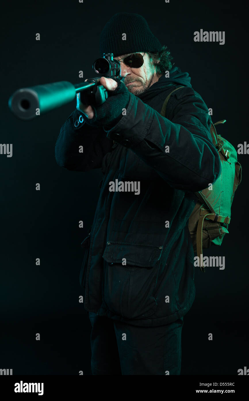 Sniper with beard in black holding gun. Studio shot Stock Photo - Alamy