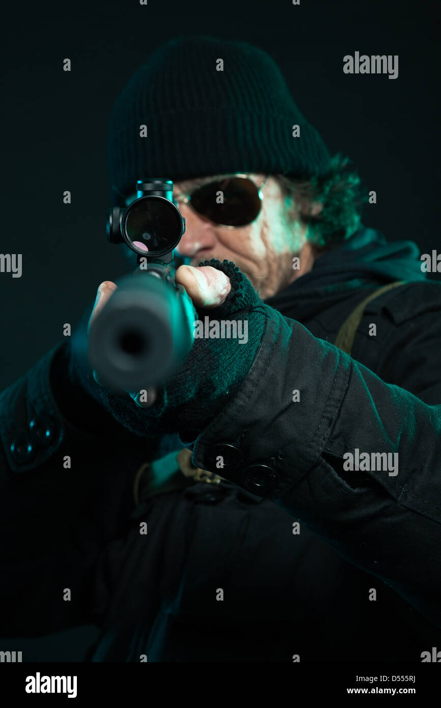 Sniper with beard in black holding gun. Studio shot Stock Photo - Alamy
