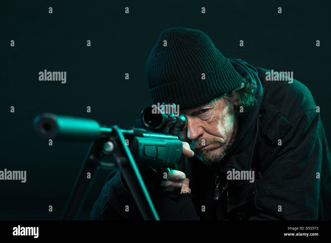 Sniper with beard in black holding gun. Studio shot Stock Photo - Alamy