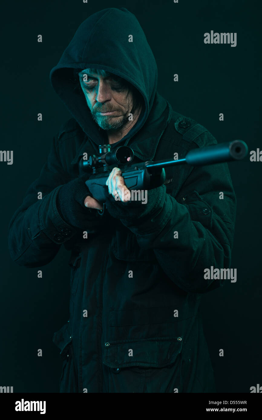 Sniper with beard in black holding gun. Studio shot Stock Photo - Alamy