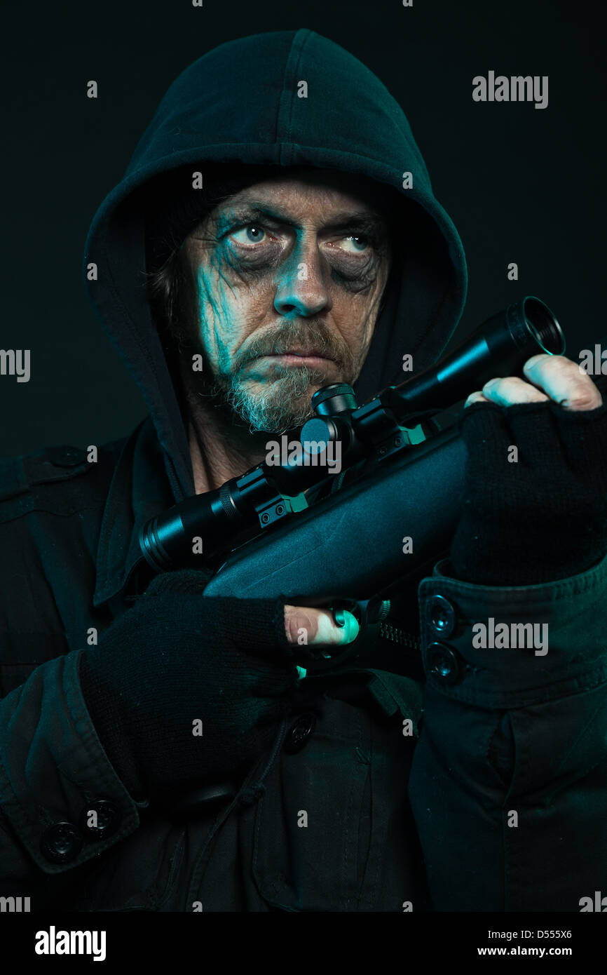 Sniper with beard in black holding gun. Studio shot Stock Photo - Alamy