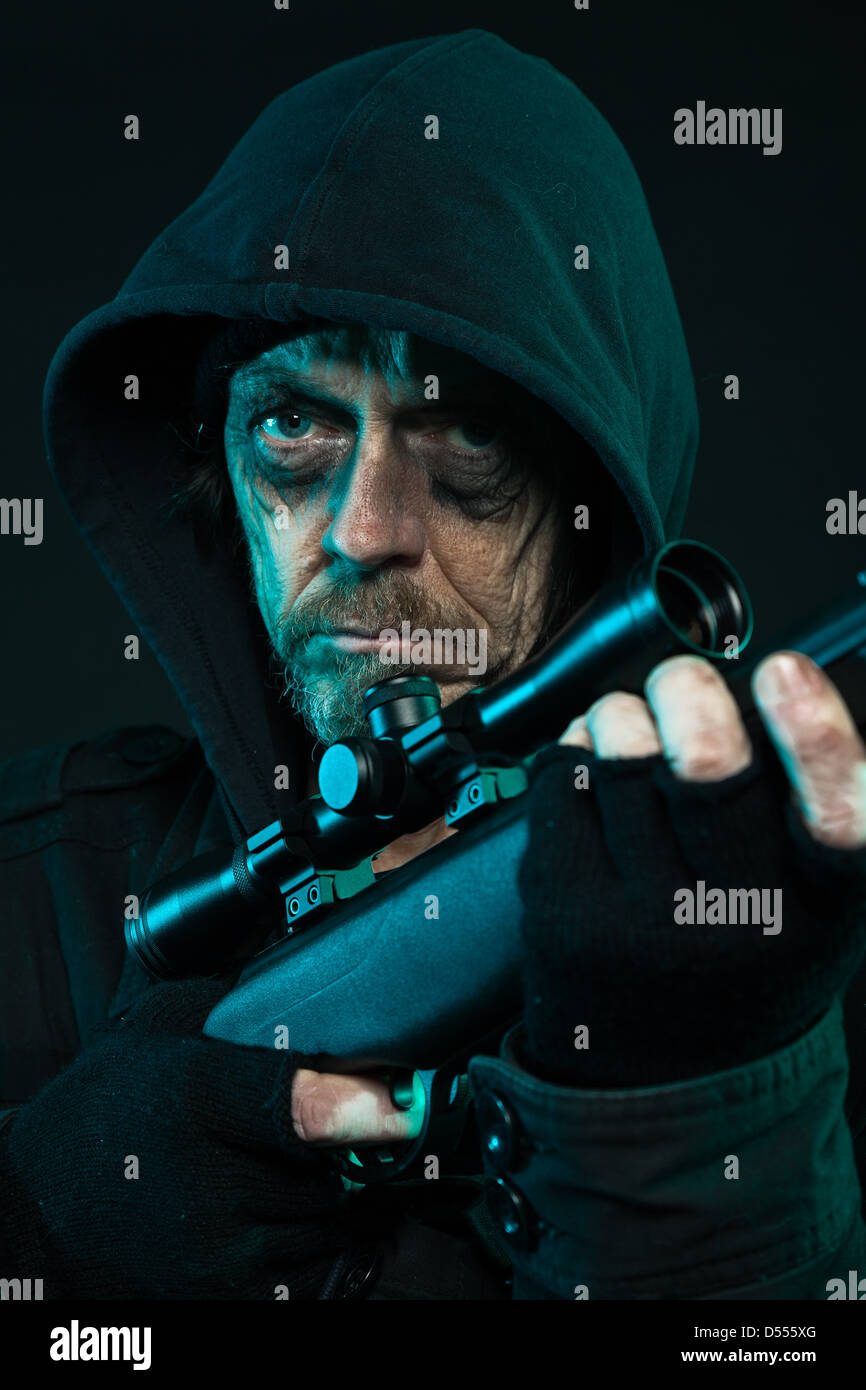 Sniper with beard in black holding gun. Studio shot Stock Photo - Alamy