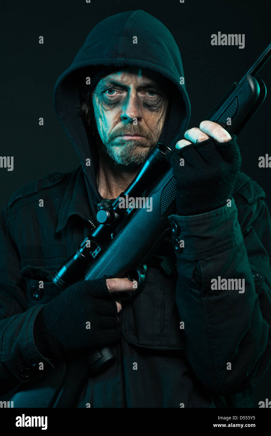 Sniper with beard in black holding gun. Studio shot Stock Photo - Alamy