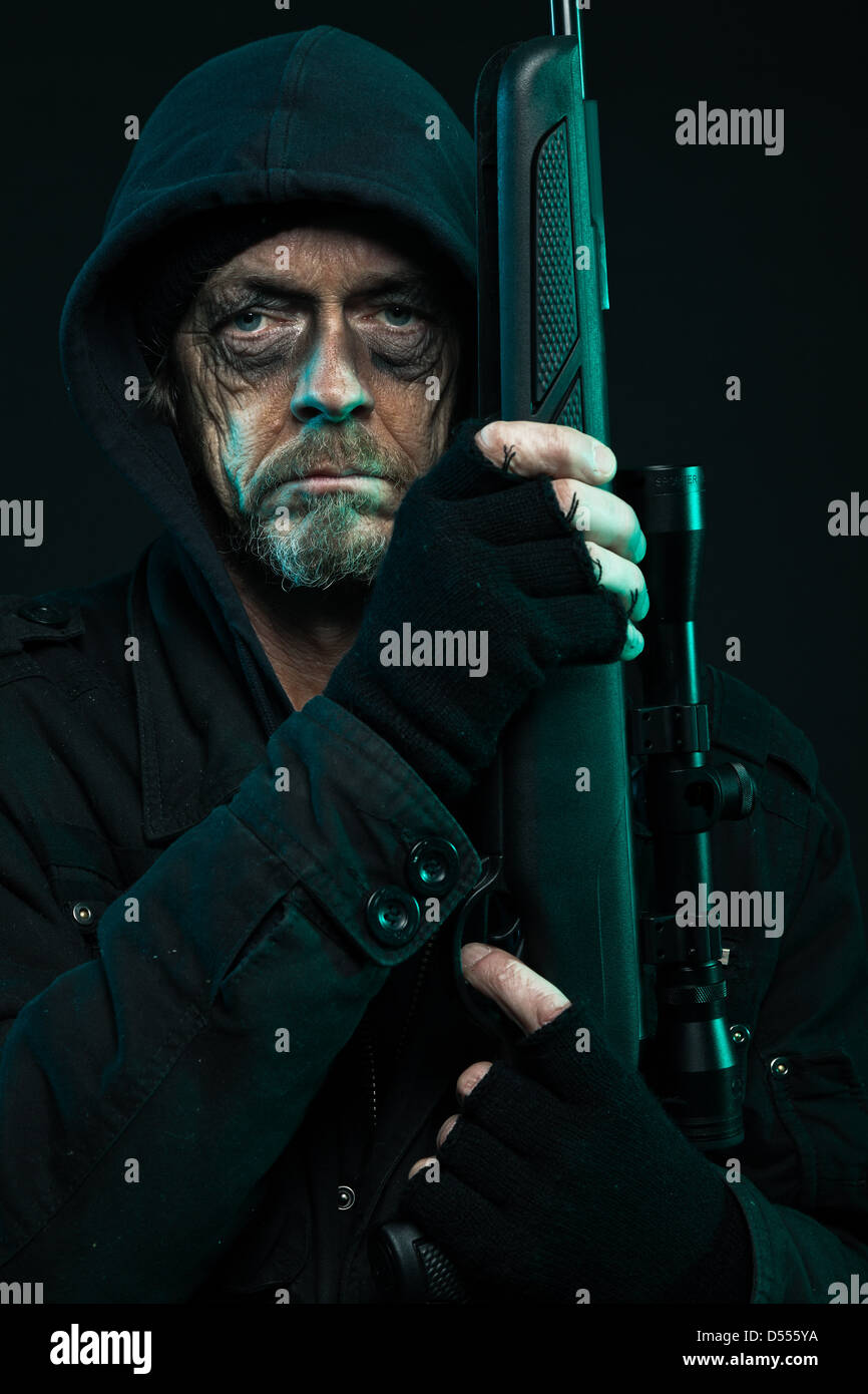 Sniper with beard in black holding gun. Studio shot Stock Photo - Alamy