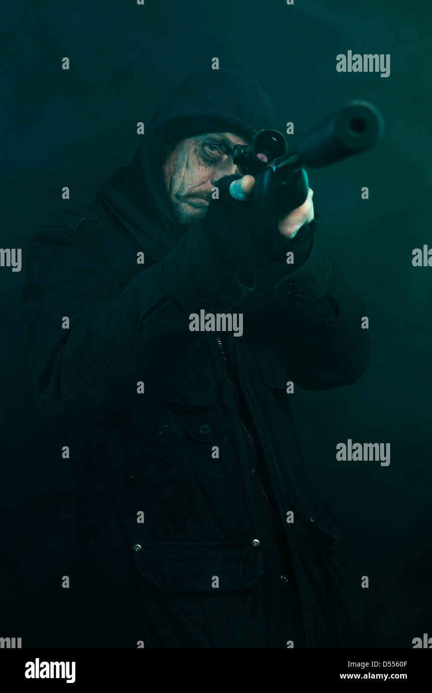 Sniper with beard in black holding gun. Studio shot Stock Photo - Alamy
