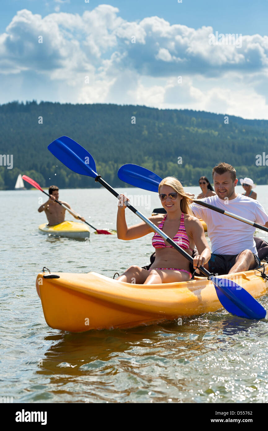 Young friends kayaking in summertime on lake holiday Stock Photo - Alamy