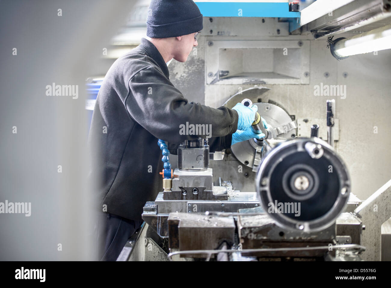 Worker using machinery in factory Stock Photo - Alamy
