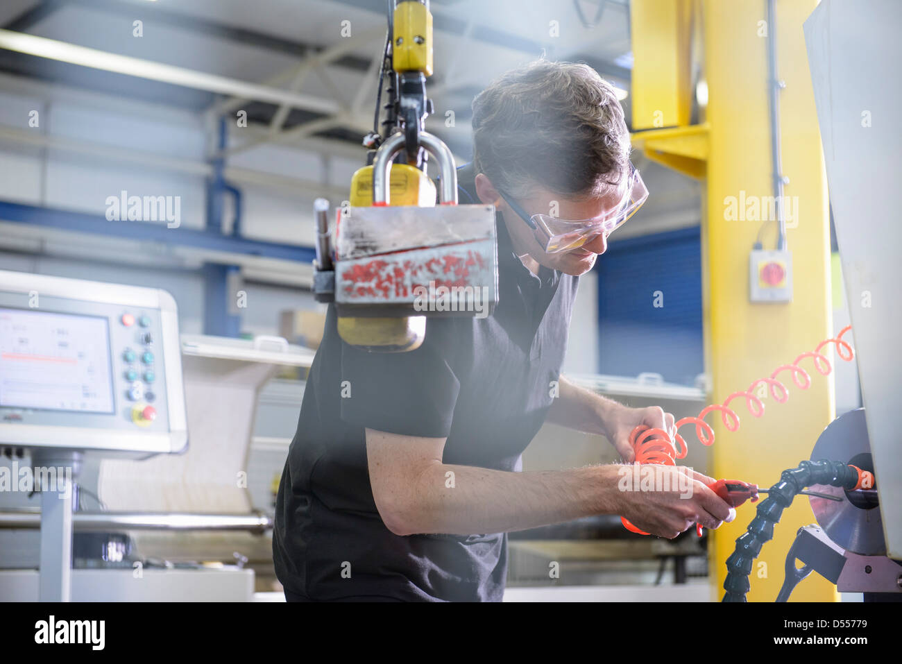 Worker using machinery in factory Stock Photo - Alamy