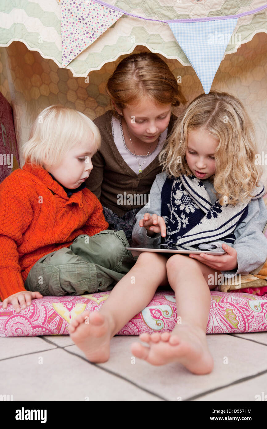 Children using tablet computer in fort Stock Photo - Alamy