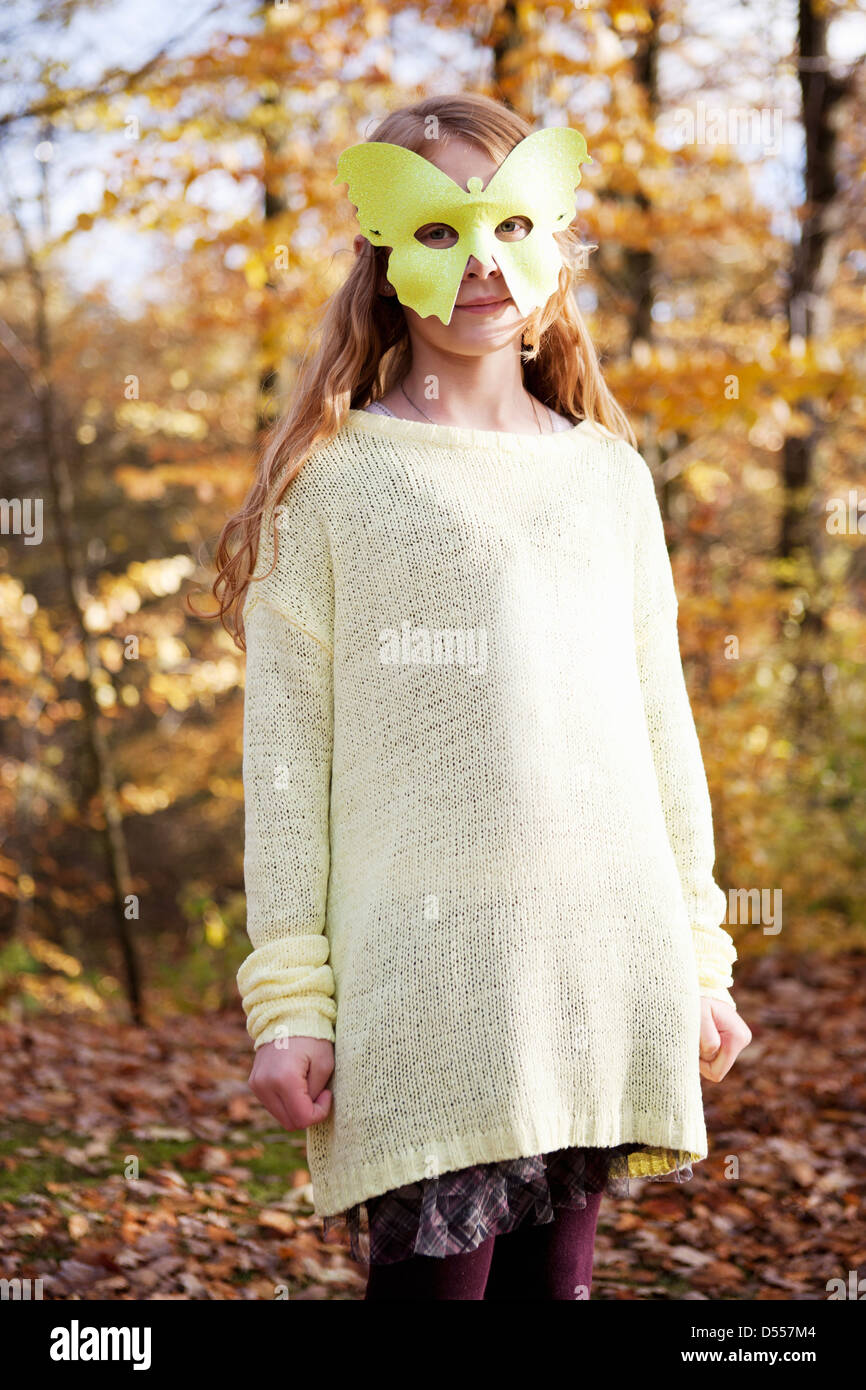 Girl wearing butterfly mask in park Stock Photo - Alamy