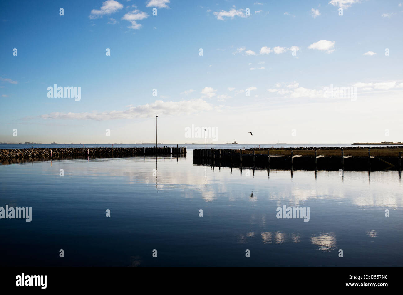 Sky reflected in still harbor Stock Photo - Alamy