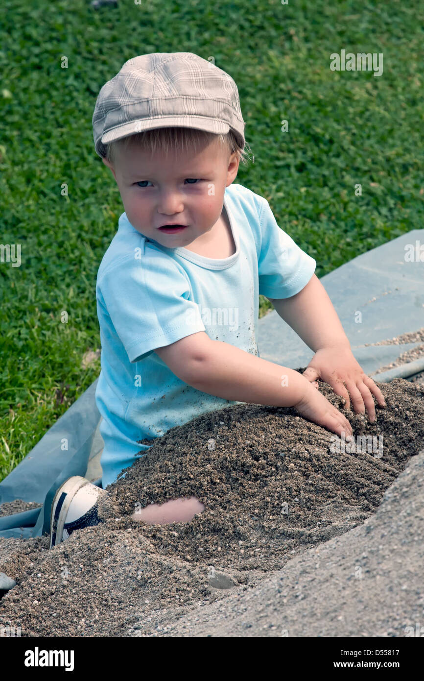 Toddler boy playing with the sand Stock Photo - Alamy