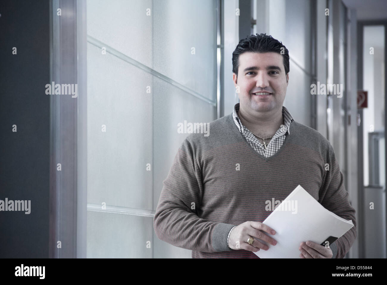 Man holding folder in hallway Stock Photo - Alamy