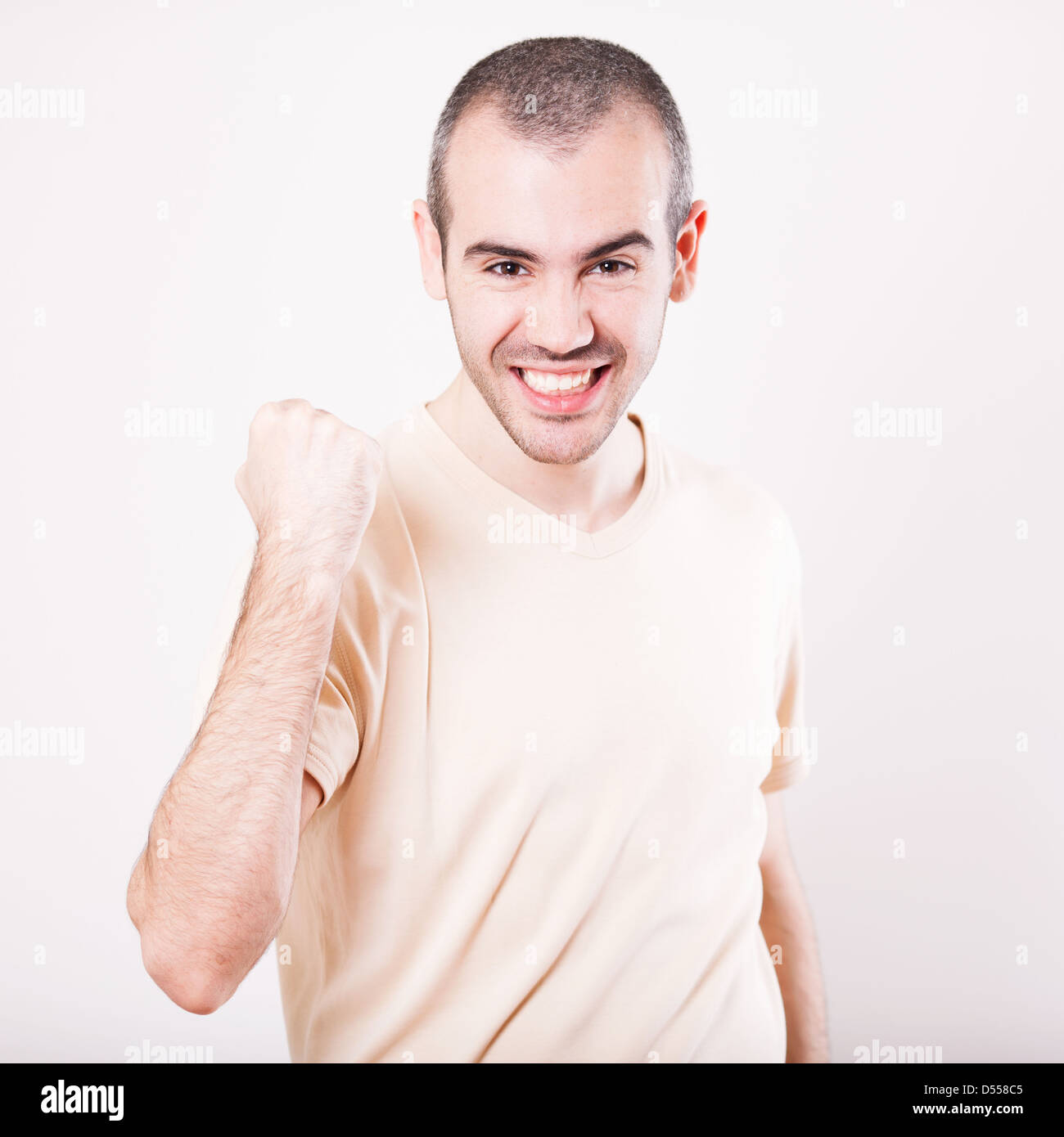 Portrait of an excited young man celebrating success with raised hand ...