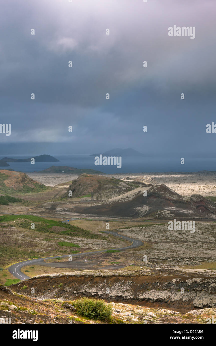 Highway through Iceland landscape at overcast day with rainbow ...