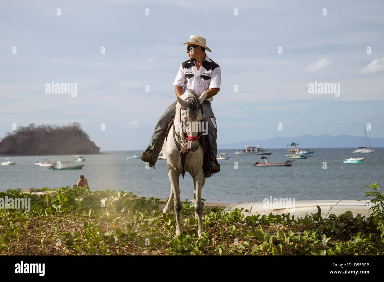 Costa Rican cowboy riding horse on the beach at Playas del Coco ...