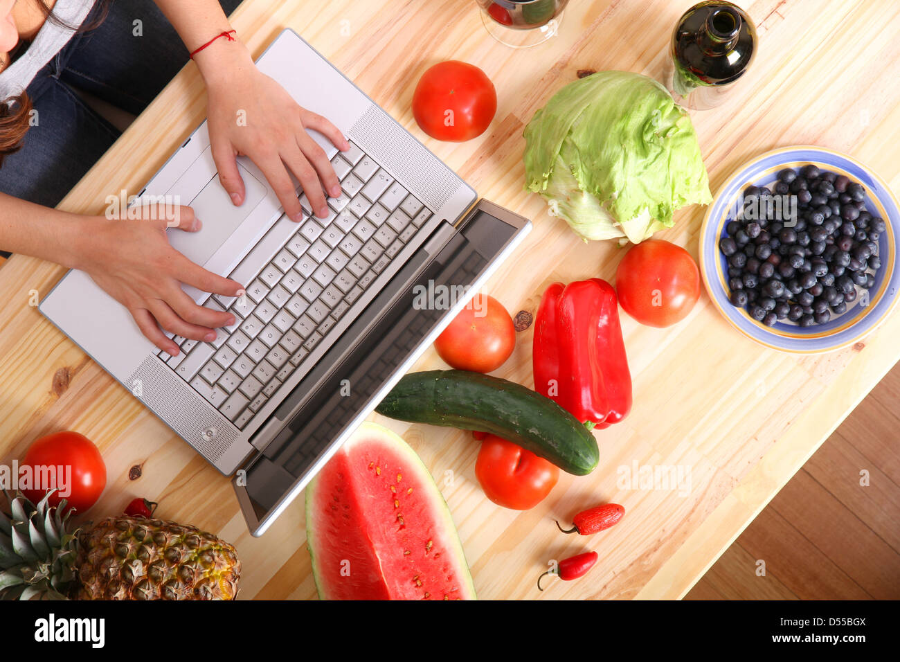 A young woman using a Laptop while cooking Stock Photo - Alamy