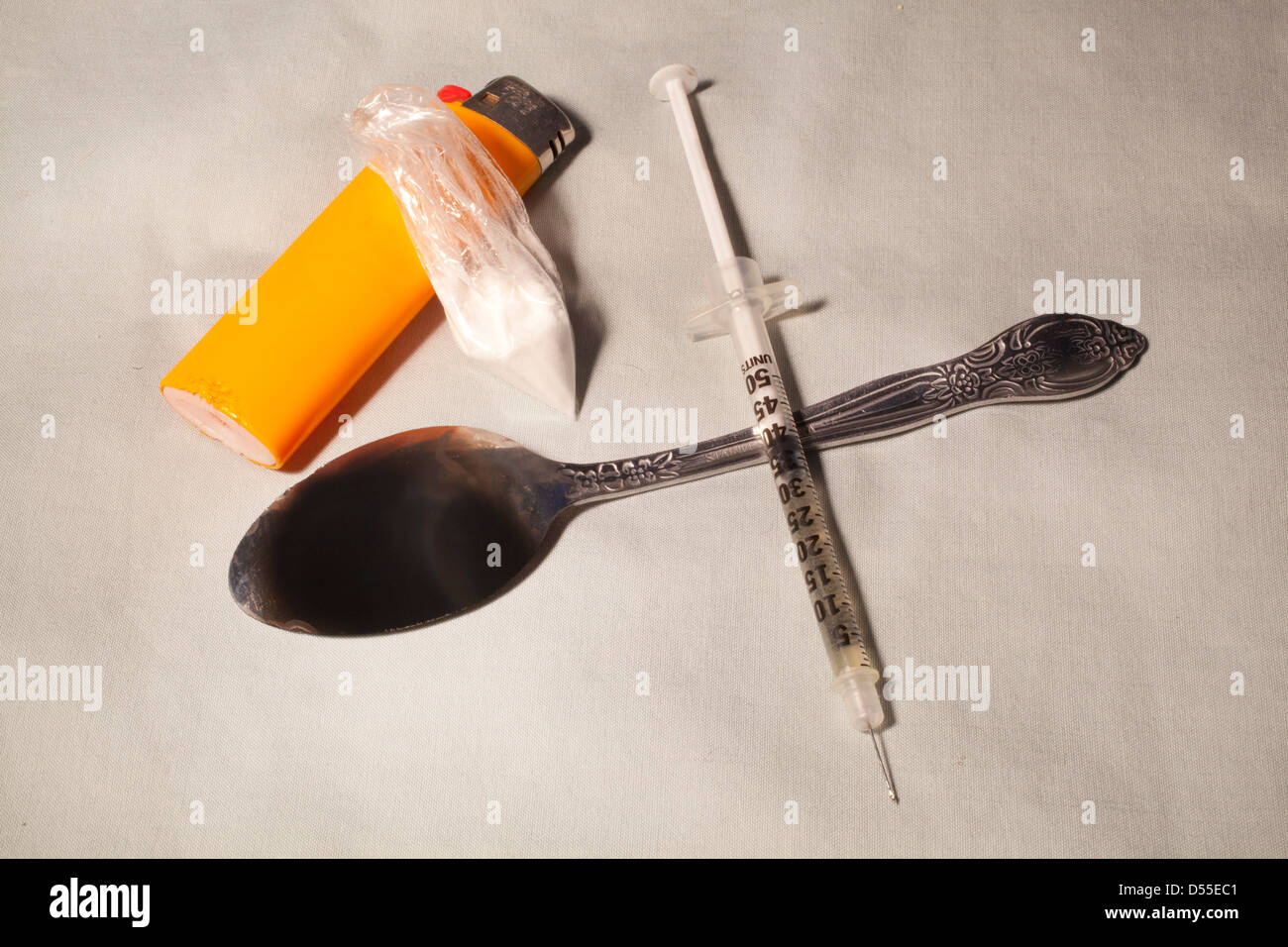 A burnt spoon, syringe, lighter, and a plastic baggie with white powder ...