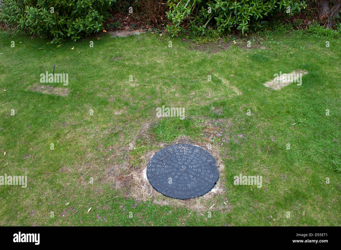 Round manhole cover in garden Stock Photo - Alamy