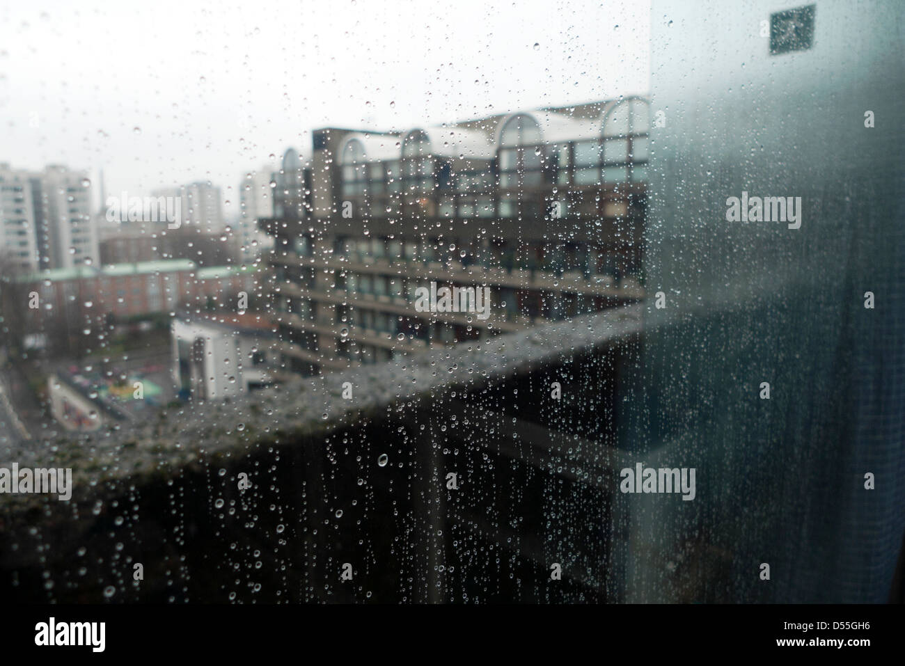 Raindrops on a window looking out from inside of a Barbican Estate flat ...