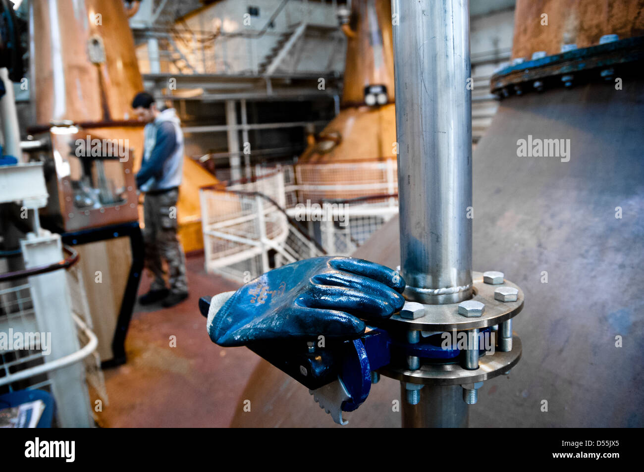 Rubber gloves lie on machinery with operator in background Stock Photo ...