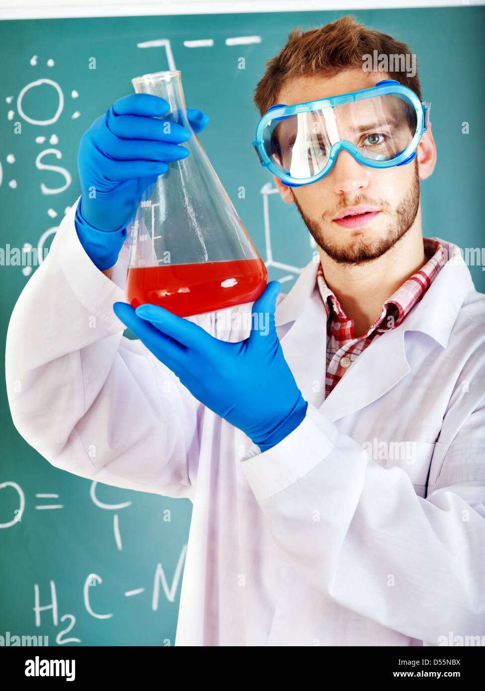 Chemistry man with flask in classroom Stock Photo - Alamy